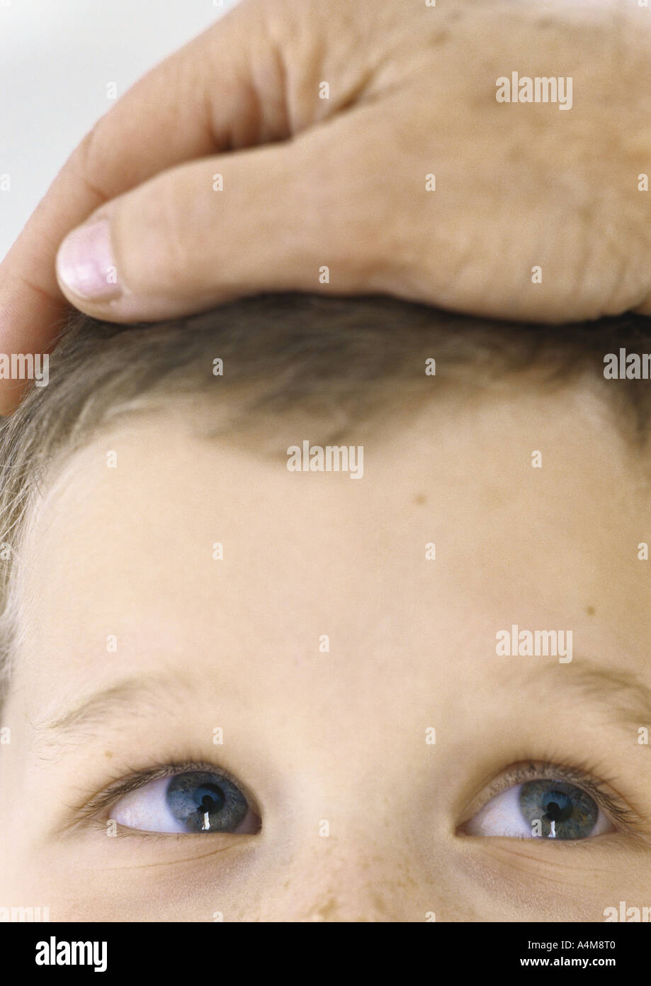 Adult's hand on child's head, close-up Stock Photo - Alamy