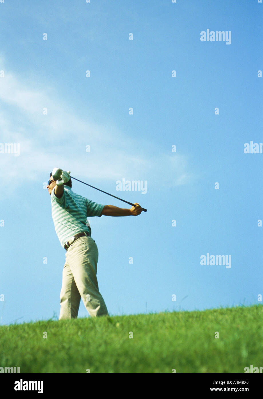 Golfer stretching with golf club Stock Photo - Alamy