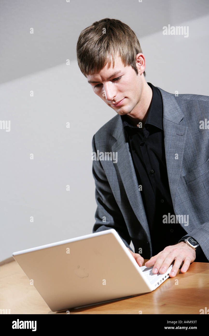 Male person working with a laptop computer Stock Photo - Alamy