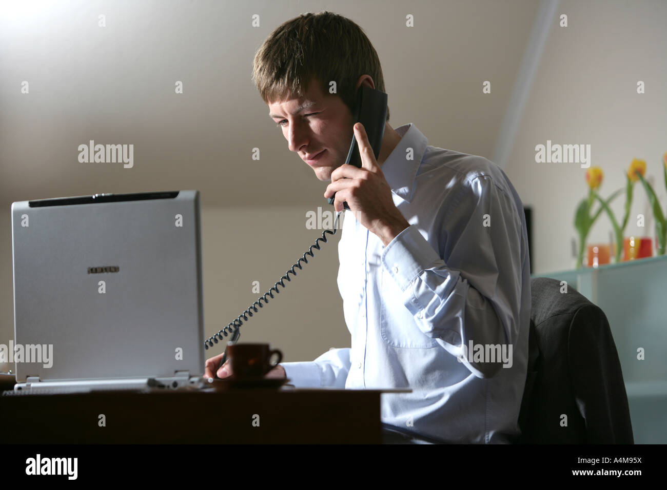 DEU Germany Young man is working at a desk with laptop computer on the ...