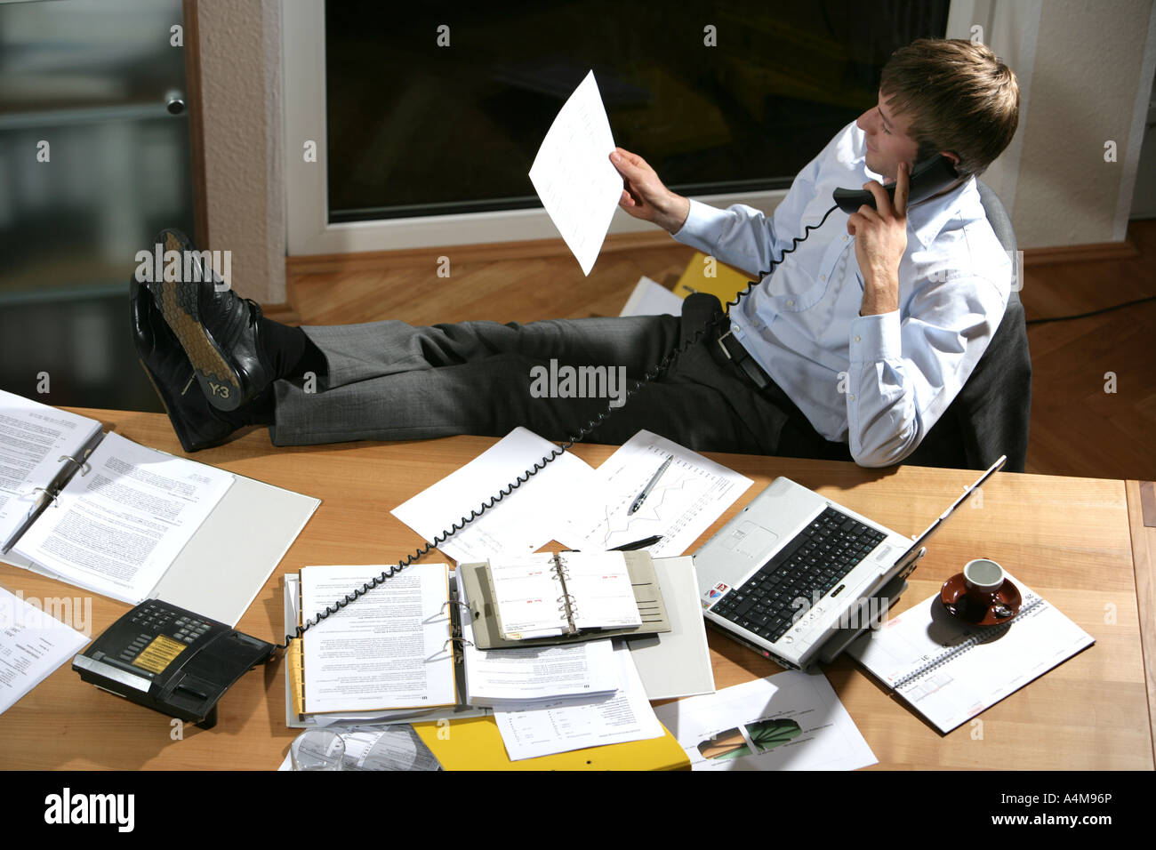 DEU Germany Young man is working at a desk with laptop computer on the ...