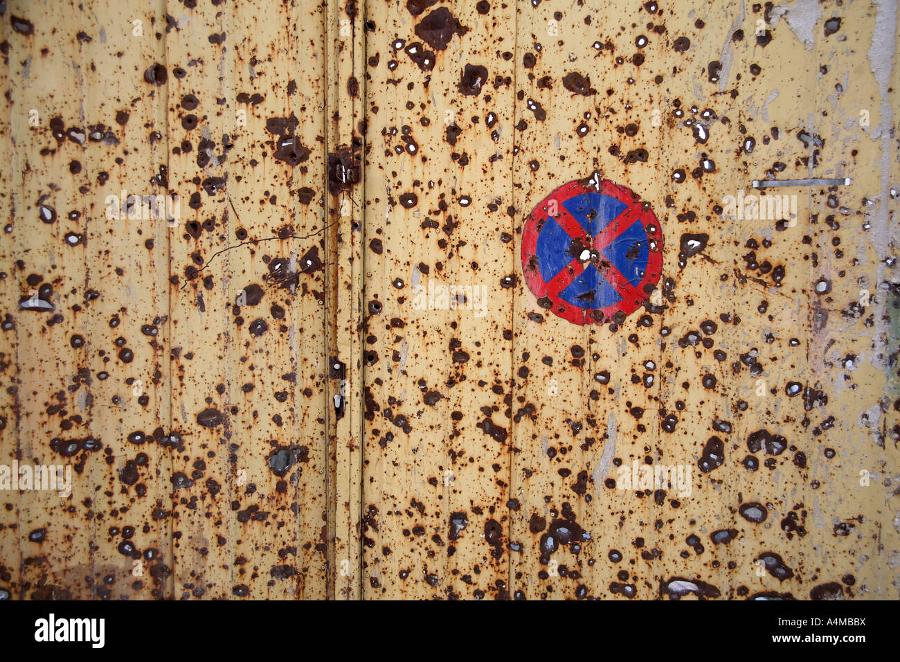 No Parking / No Stopping sign painted on damaged metal gate. Mostar ...