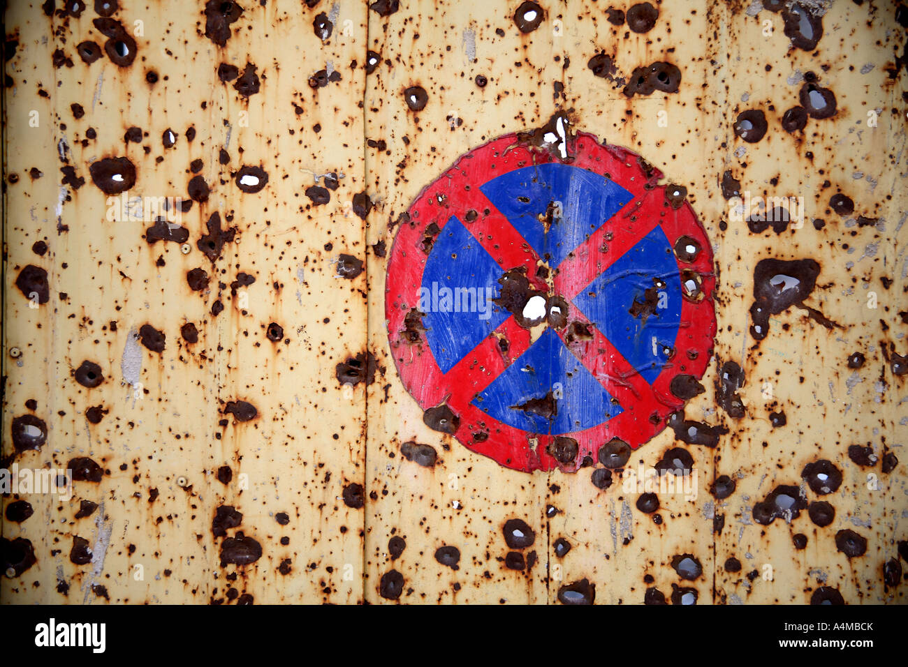 No Parking / No Stopping sign painted on damaged metal gate. Mostar ...