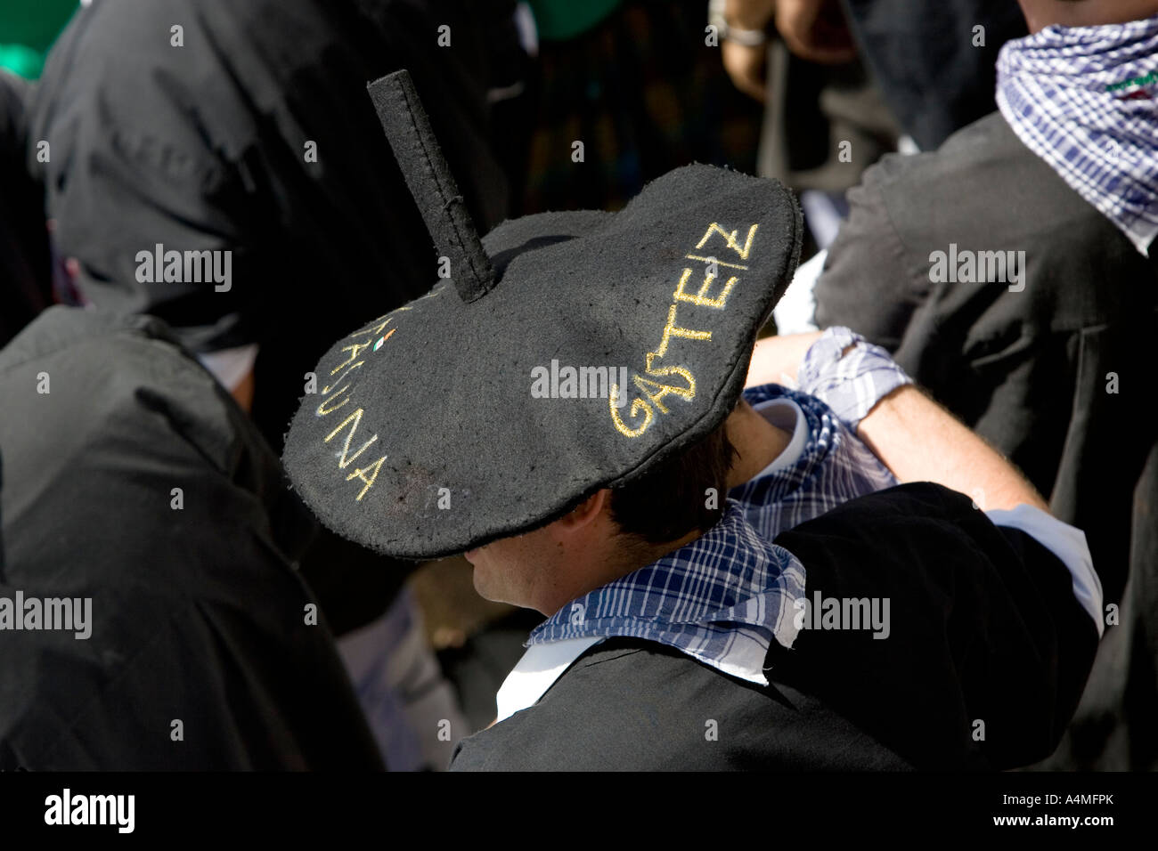 Man wearing oversize black beret with word 'Gasteiz' in gold, church of ...