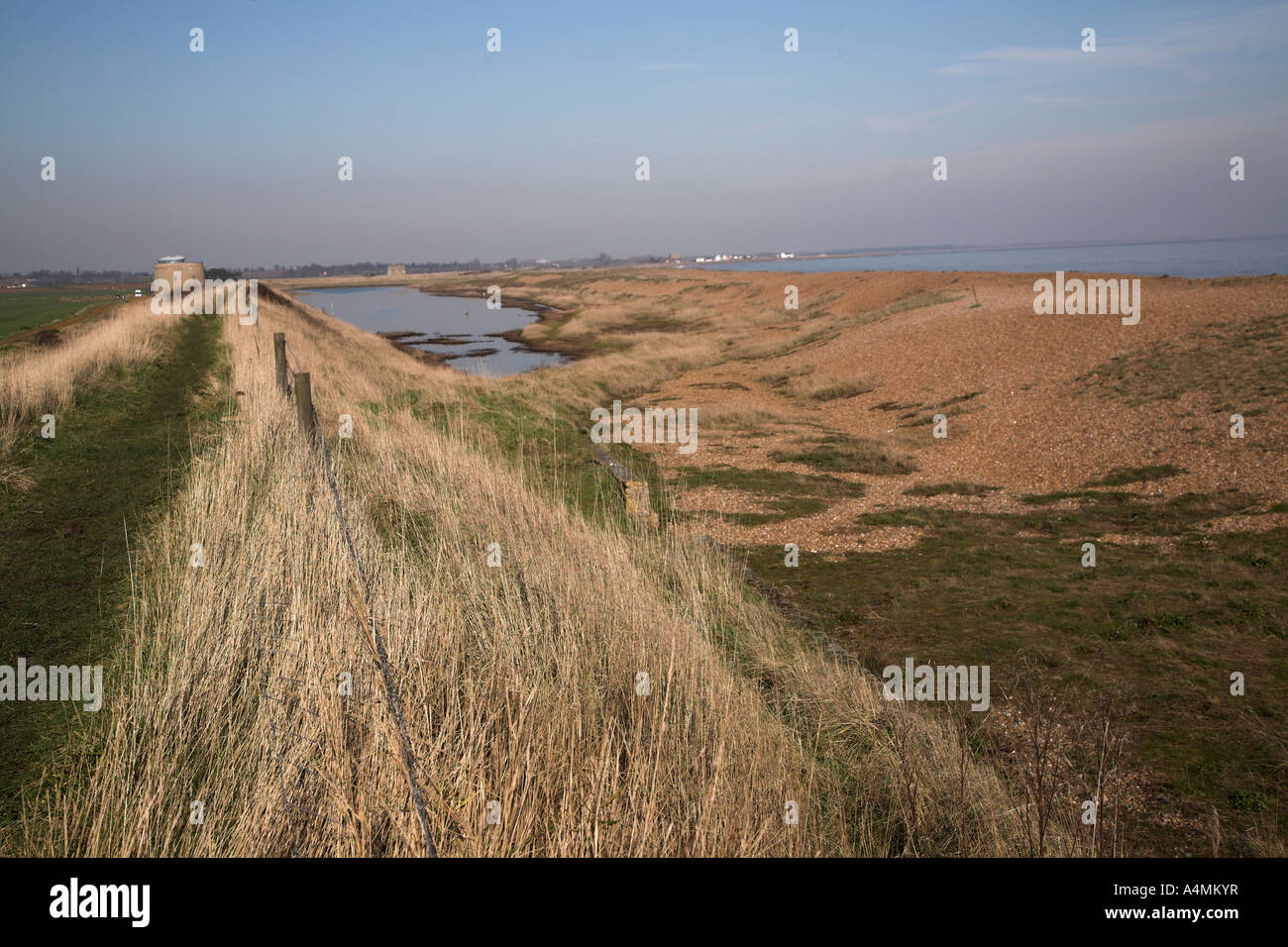 Shingle bar lagoon and flood defence dyke wall barrier looking towards ...
