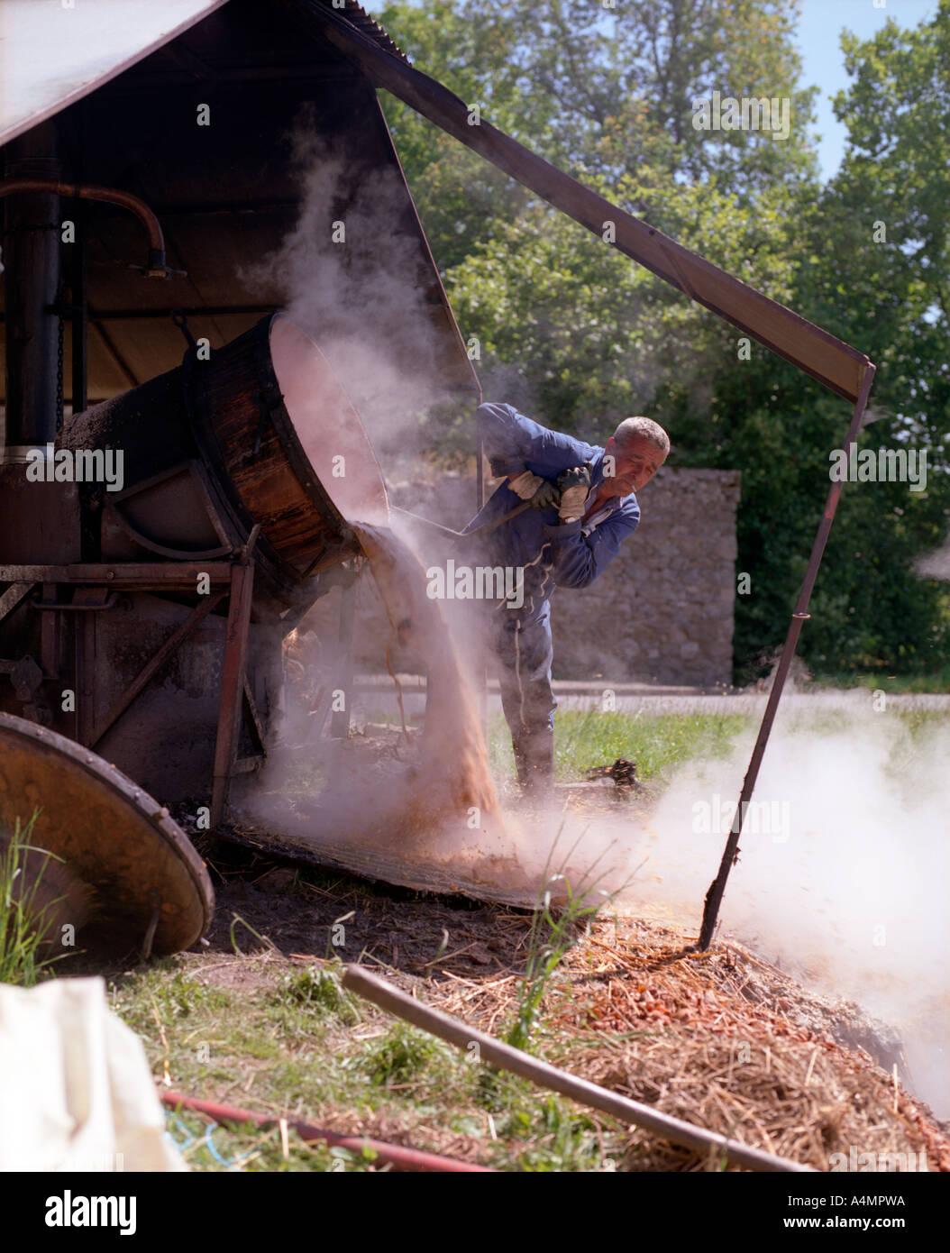 Man empties the boiling water and steam from a traditional mobile ...