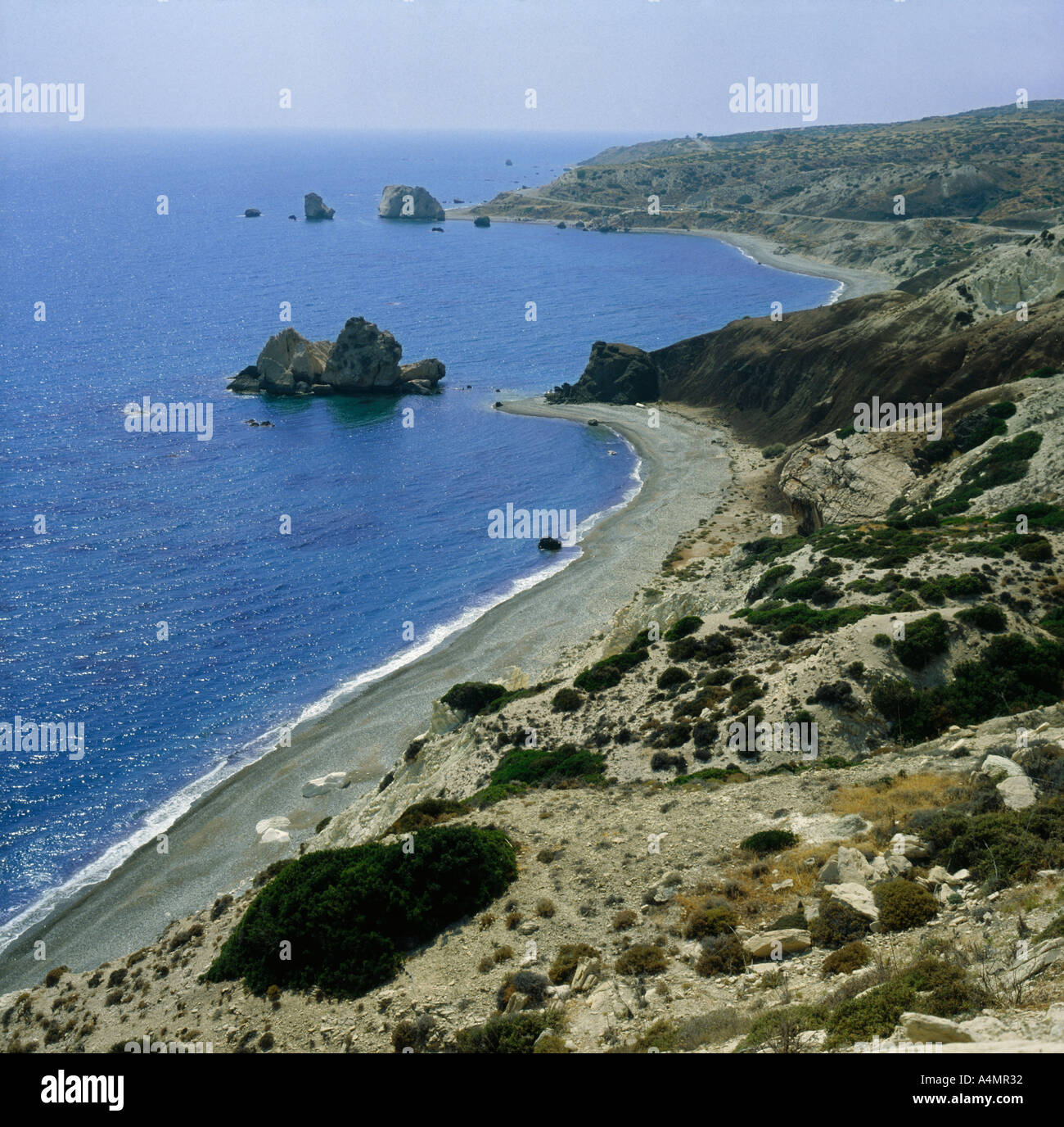 Coastal view of rugged cliffs sloping down to sea with Aphrodites Beach ...