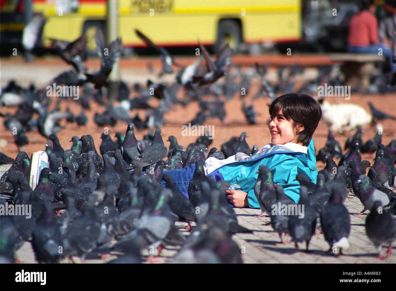 A smiling boy lies among the pigeons in front of the National Congress ...