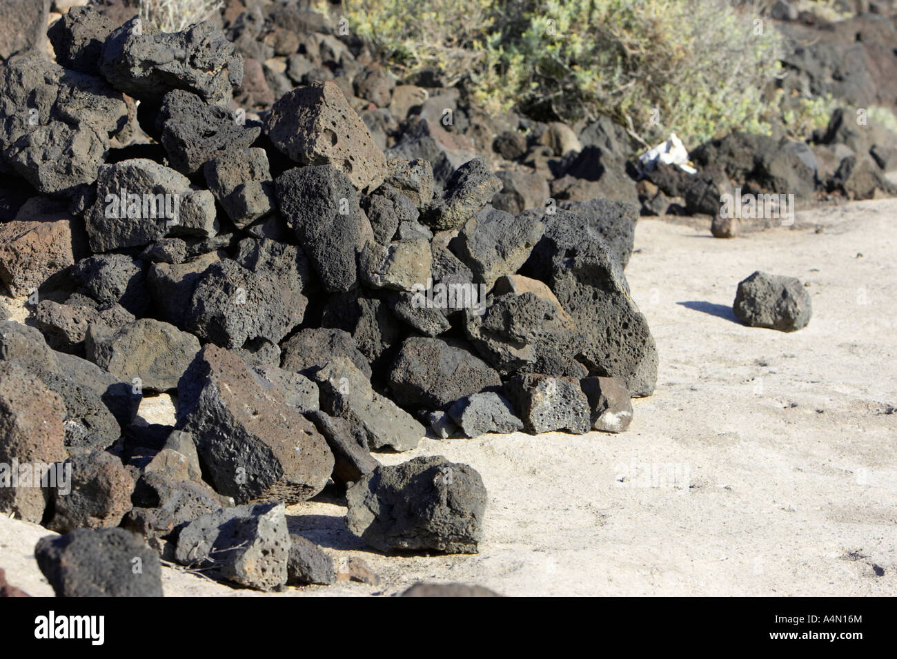 pile of rocky volcanic lava rock boulders on the beach coastline at ...