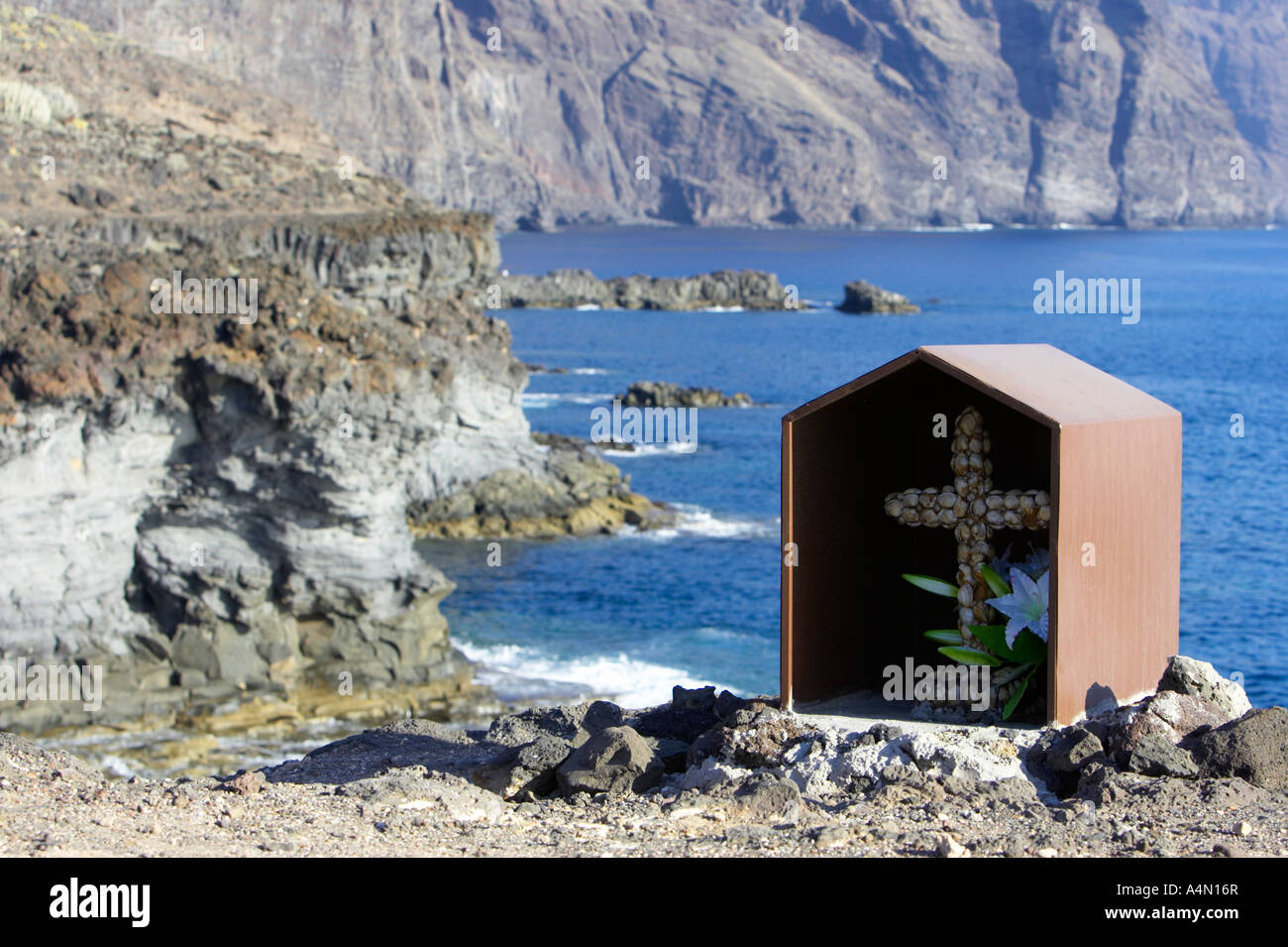 small shrine with cross made out of sea shells on rocky coastline at ...