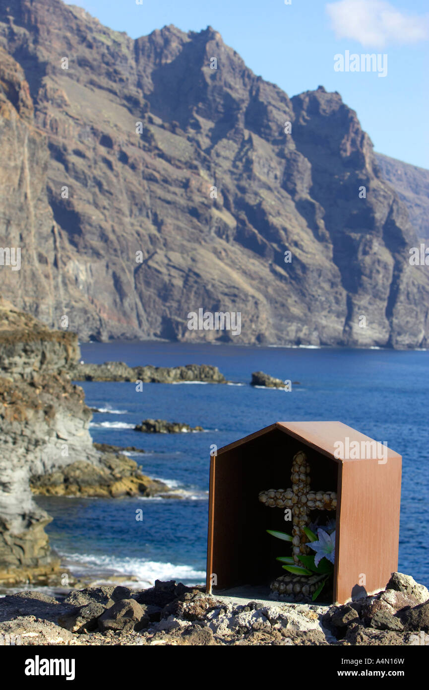 vertical small shrine with cross made out of sea shells on rocky ...