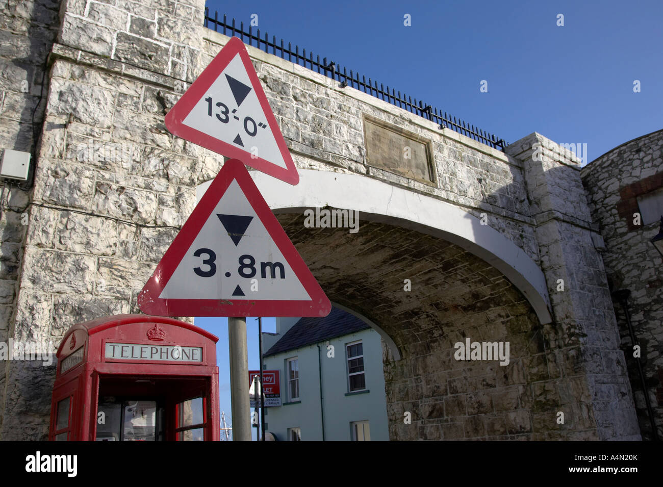 red triangular height warning signs in front of white limestone bridge ...