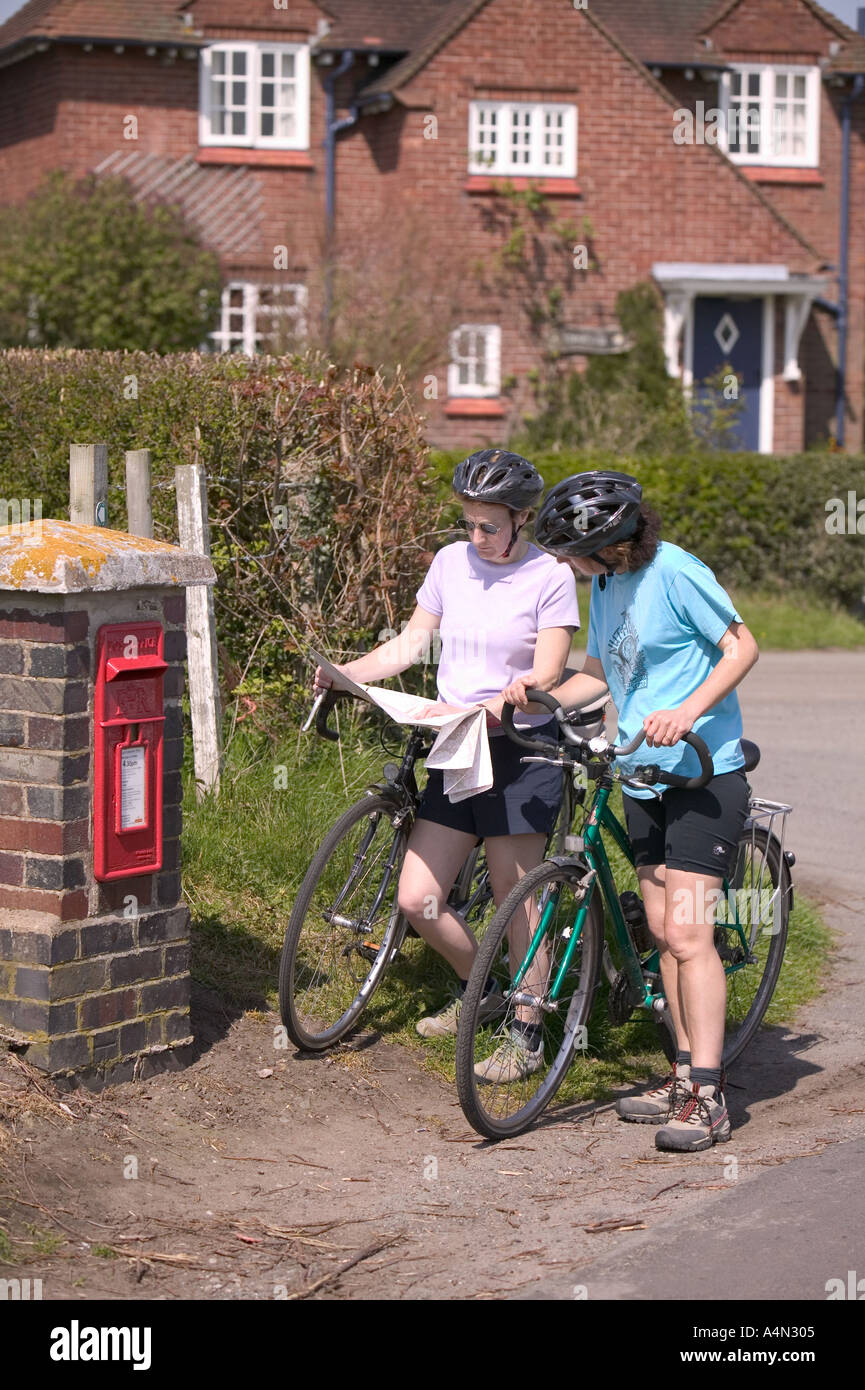 2 women cyclists stop to check route on map Cheshire Stock Photo - Alamy