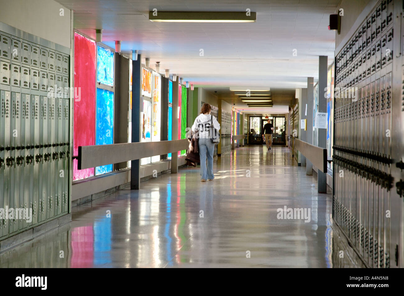 Teenage girl walking in high school hallway with lockers Stock Photo ...
