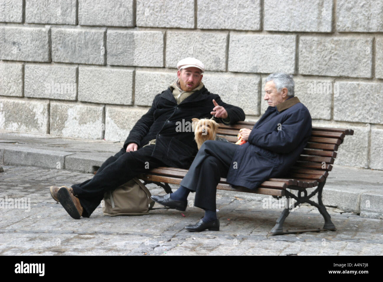 Two men sit and talk about the world, on a bench in Toledo Stock Photo ...