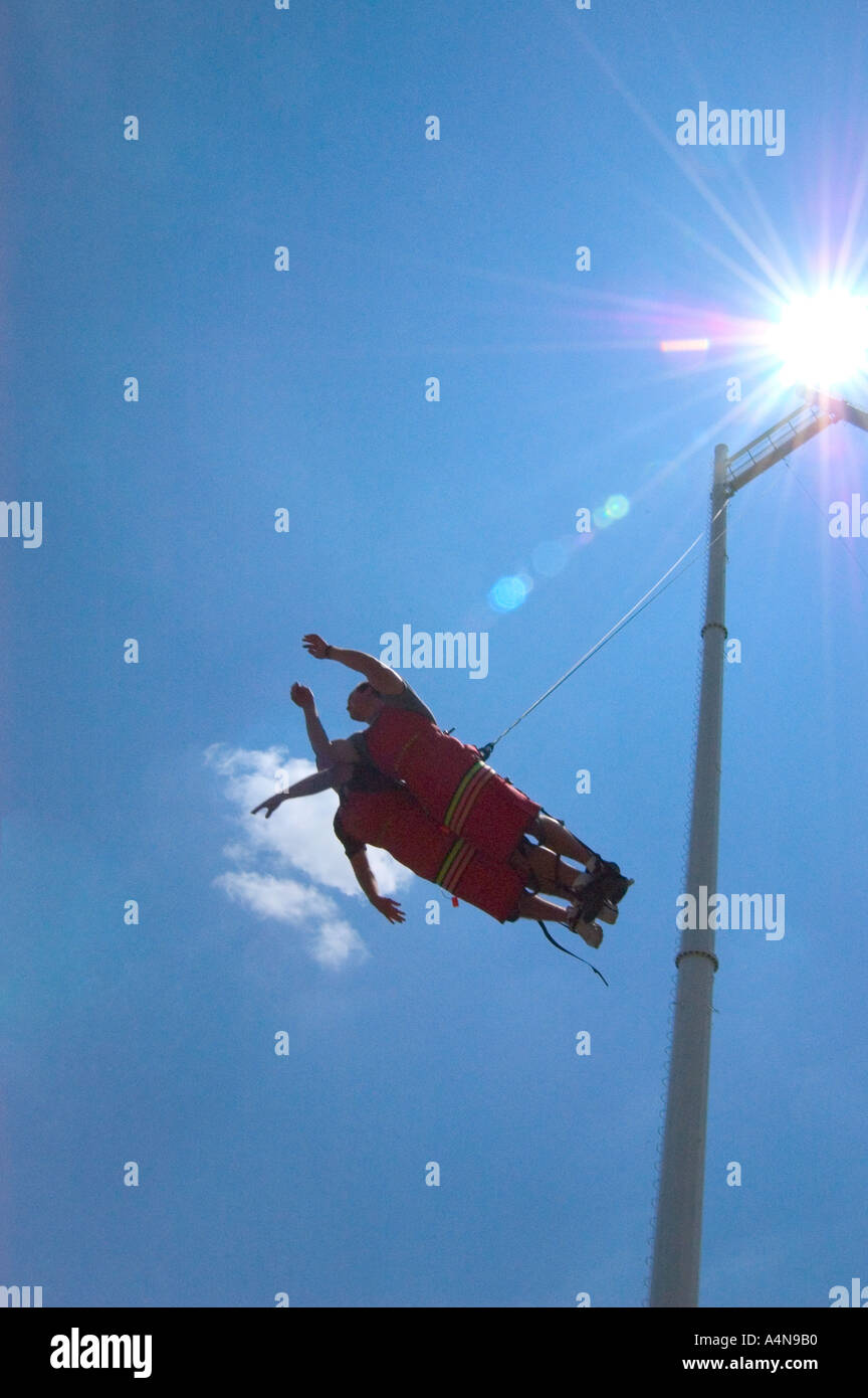 Pair of riders on bungee swing at amusement park Stock Photo - Alamy