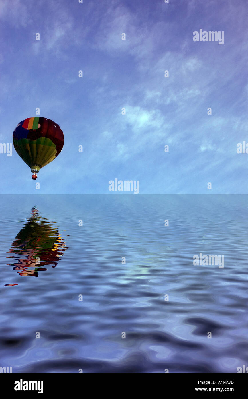 Single hot air balloon flying over quiet water Stock Photo - Alamy