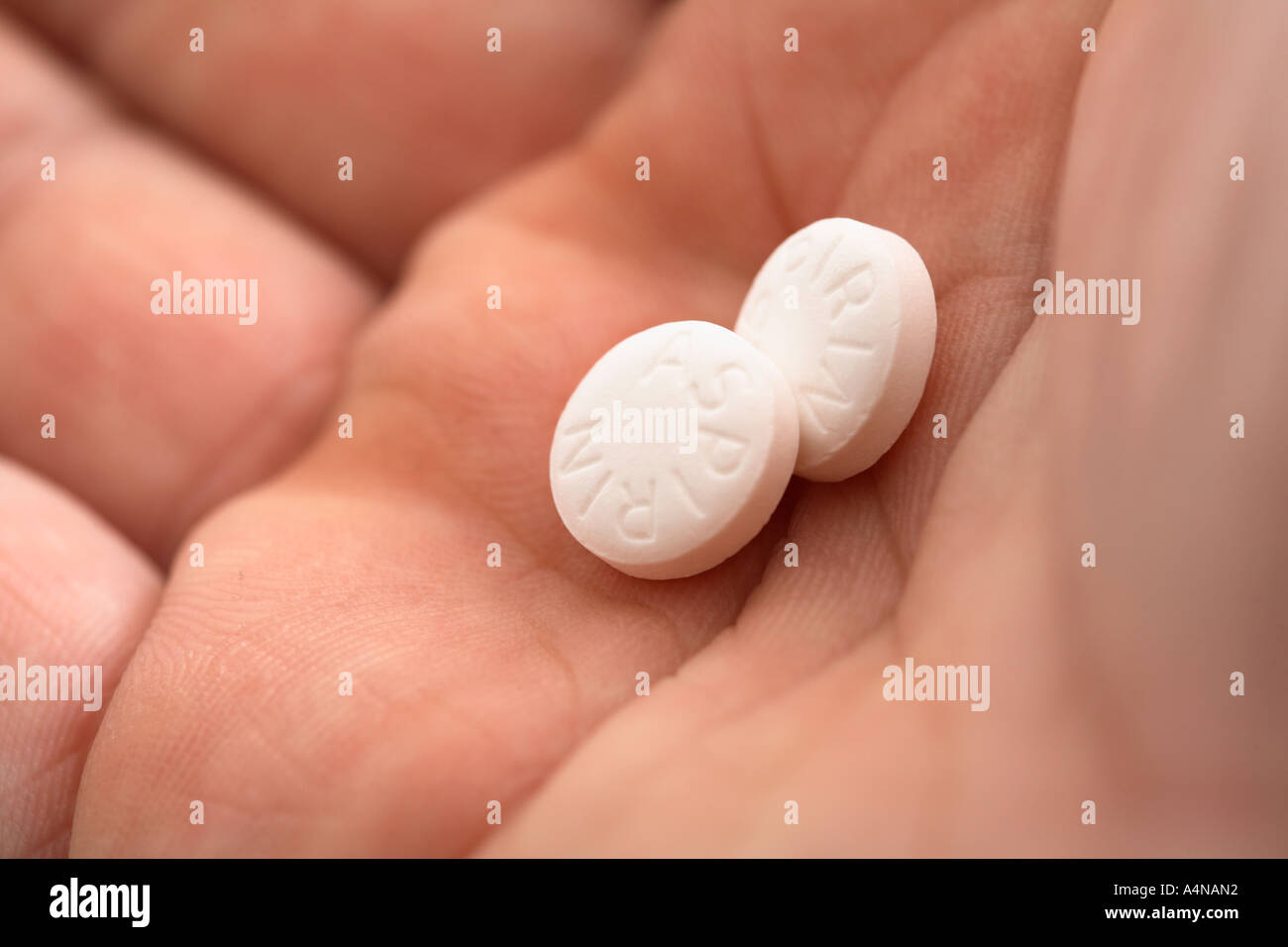 Closeup of hand holding two aspirin Stock Photo - Alamy