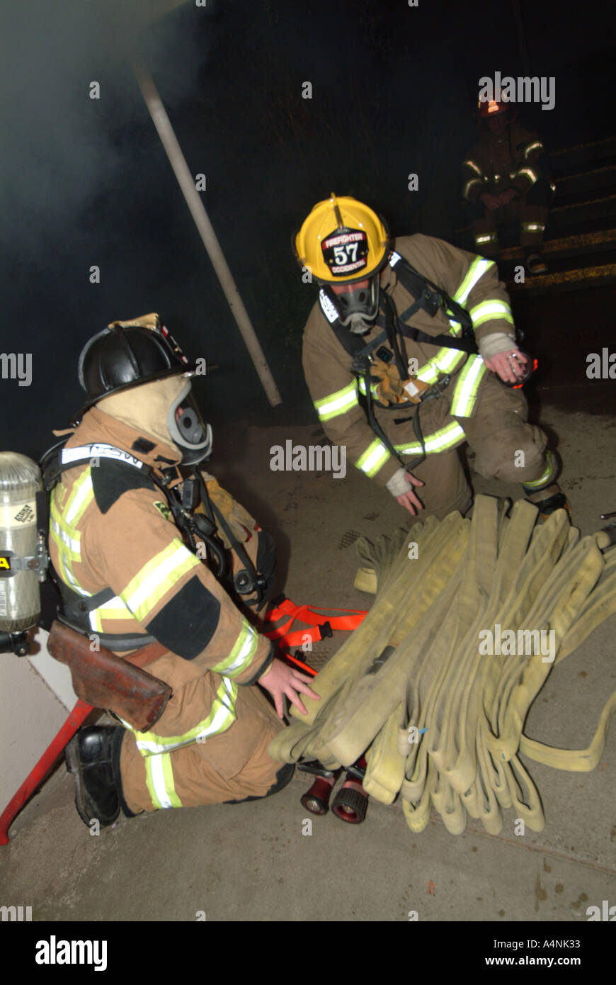 Volunteer firefighters practice fighting a school fire during a ...