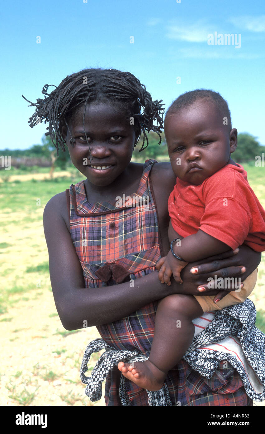 Girl of Ovambo tribe is carrying toddler near Kamajanga Ovamboland ...