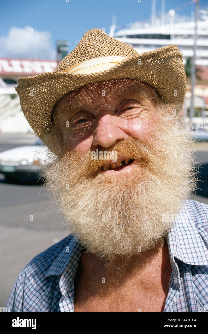 Head and shoulders portrait of an old timer with beard and straw hat ...