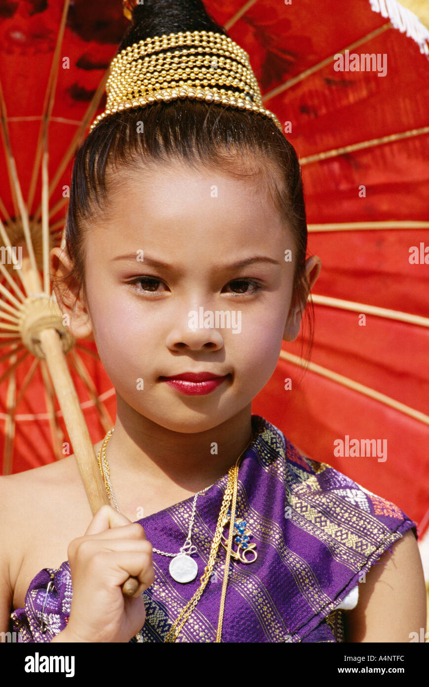 Young Laotian girl in traditional dress holding a red parasol Laos ...