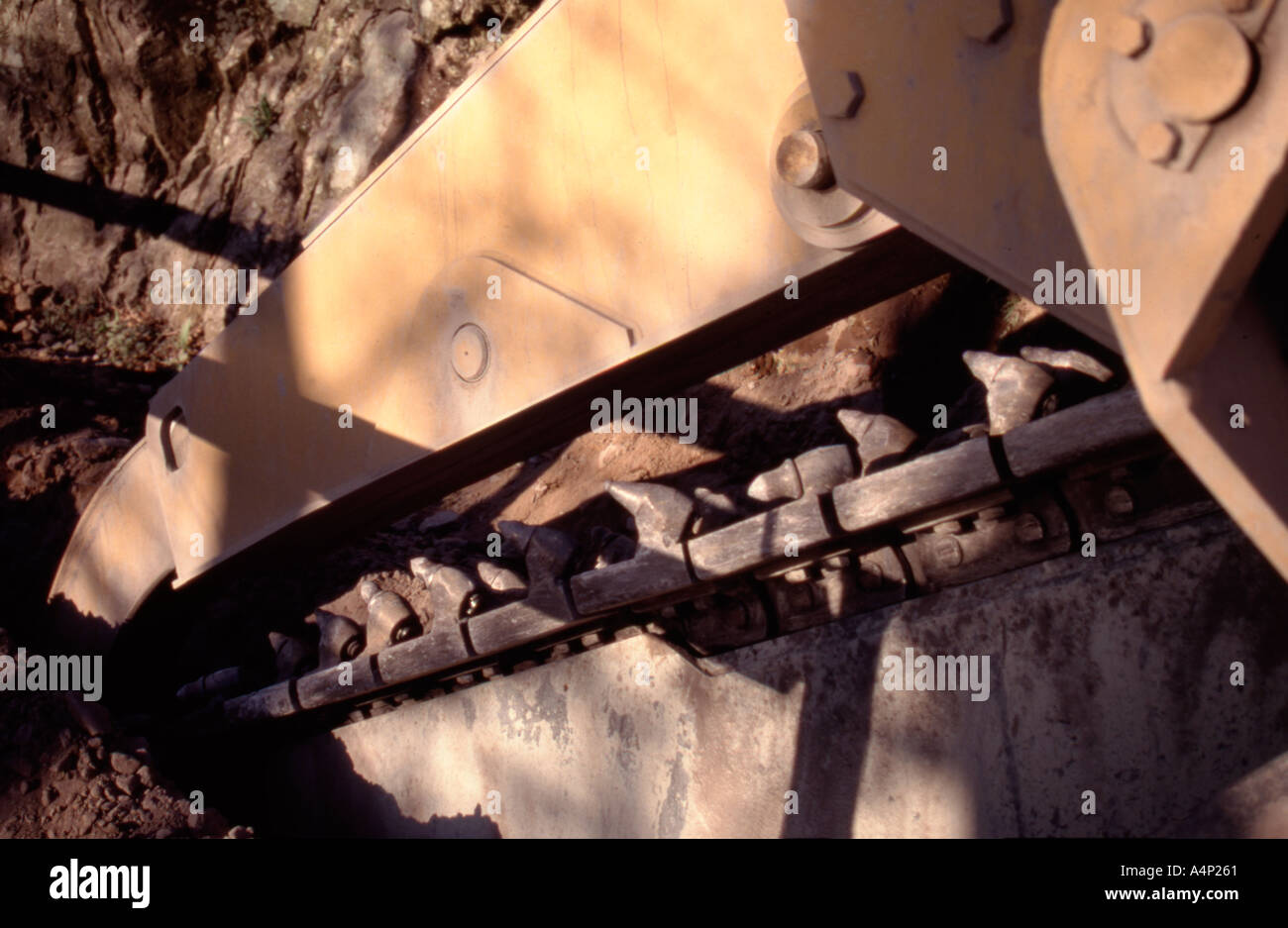 Detail of boom and teeth of a rock trenching machine, on a road in the ...