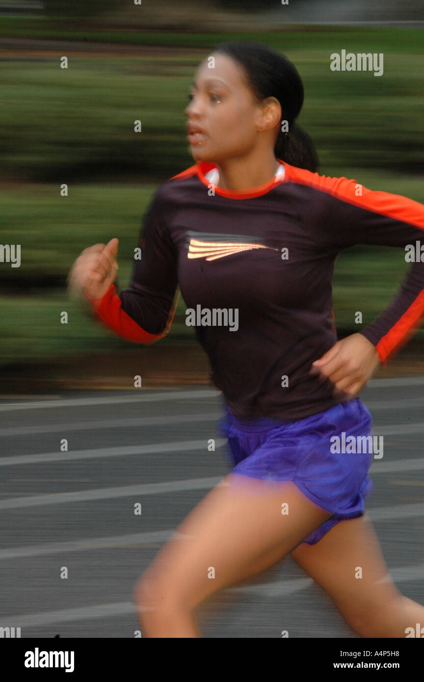 Young black African American woman running a race on a track Stock ...