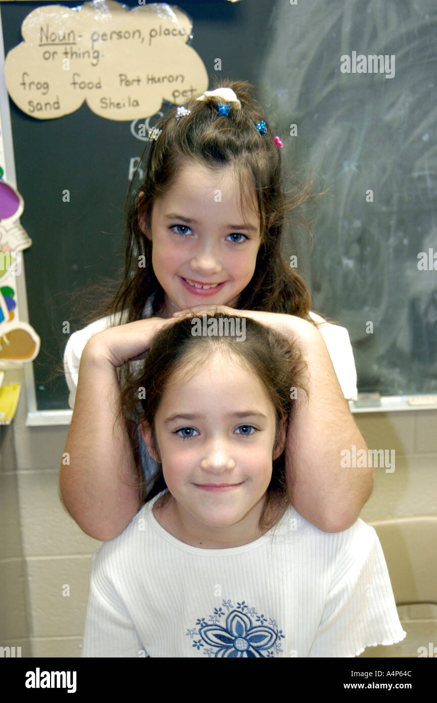 Grade 3 twin female sister students in a classroom learning situation ...