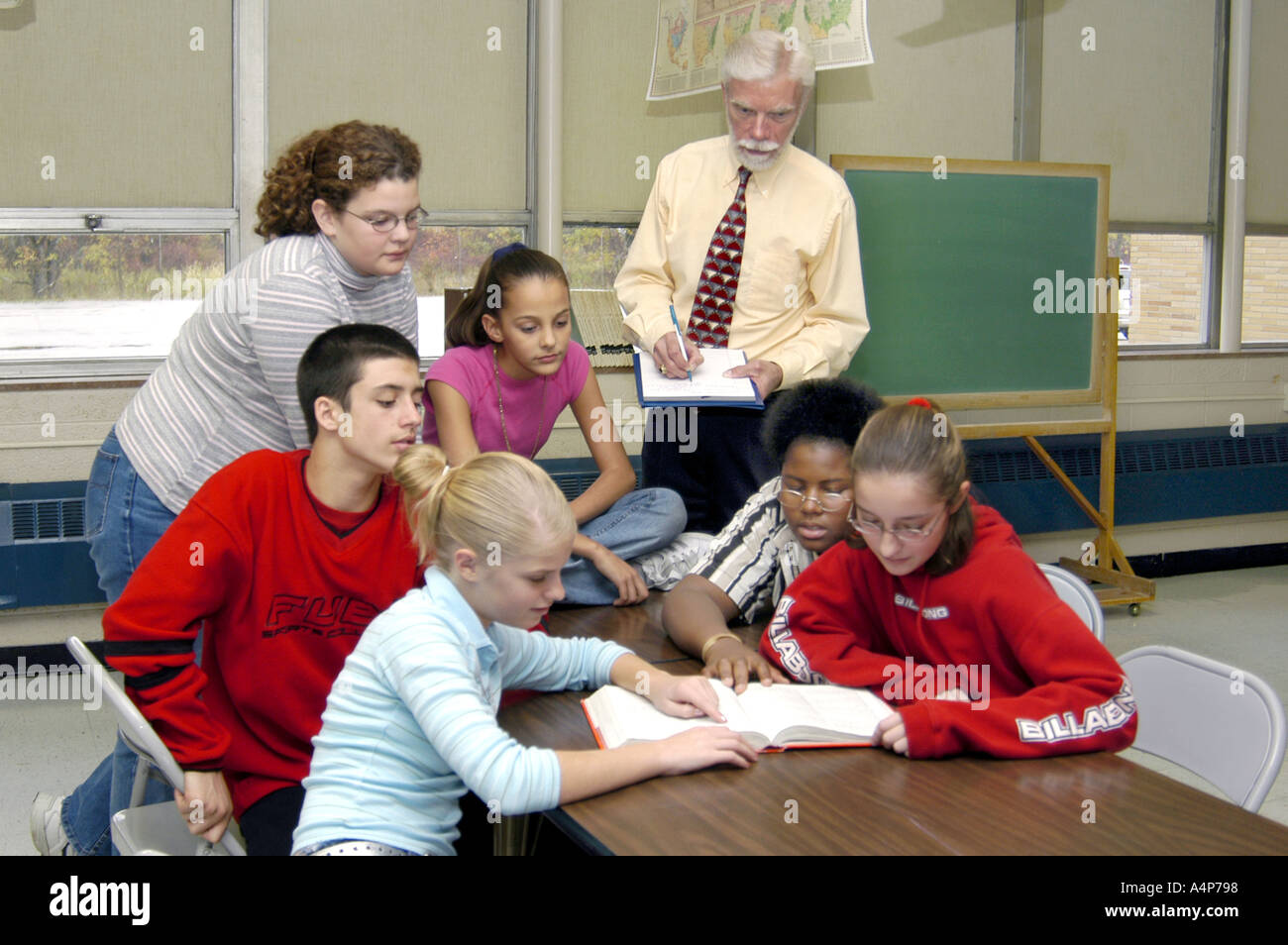 Male middle school teachers works with students in class Stock Photo ...