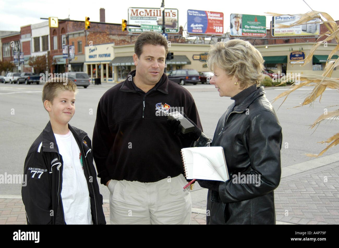 Female reporter does an in the street interview with a father and son ...