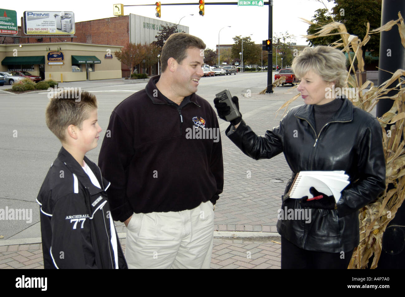 Female reporter does an in the street interview with a father and son ...
