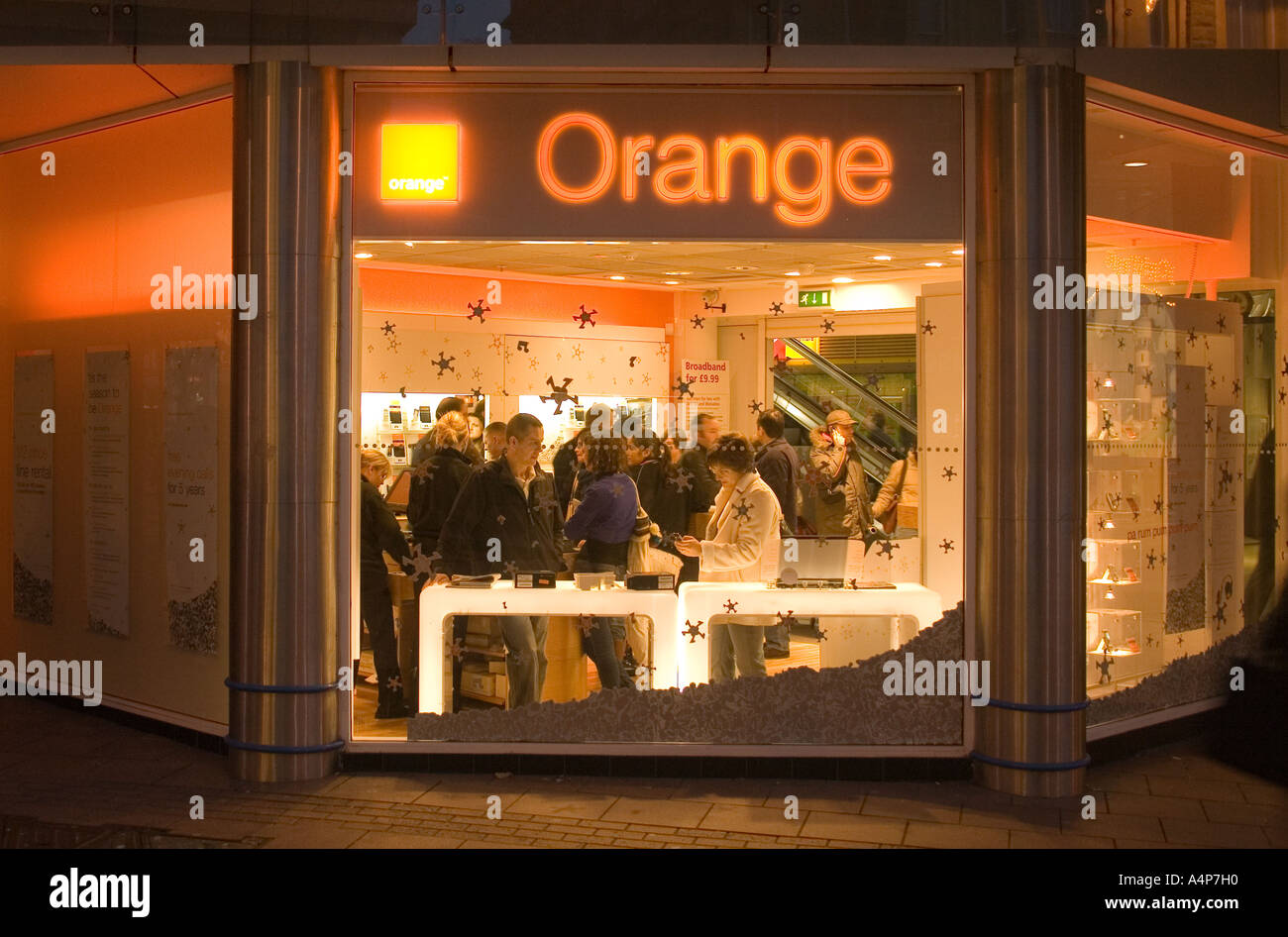 Orange mobile telephone shop at night crowded with people shopping ...