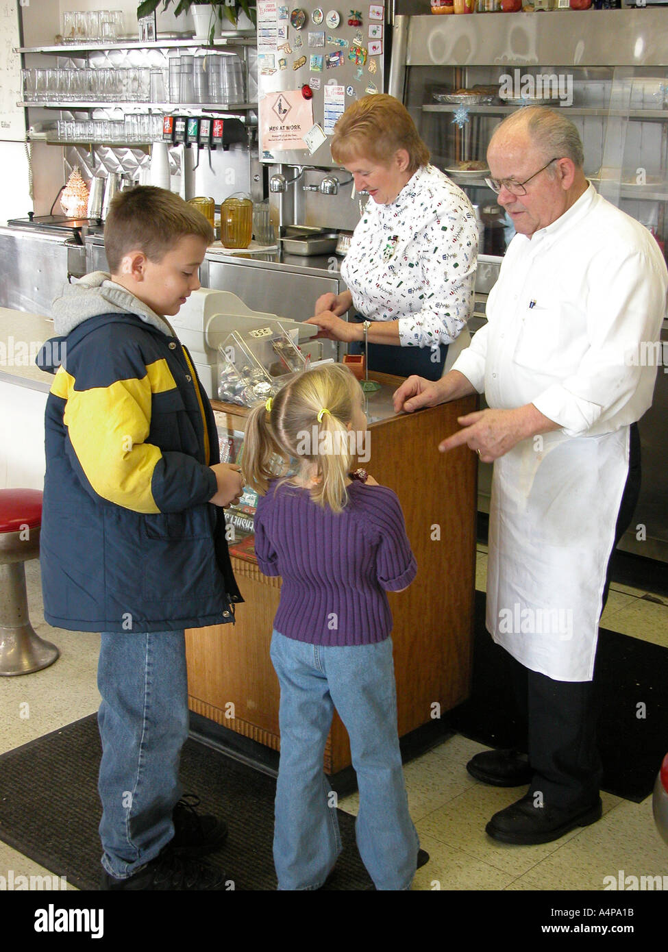 brother and sister pay bill at a small restaurant Stock Photo - Alamy
