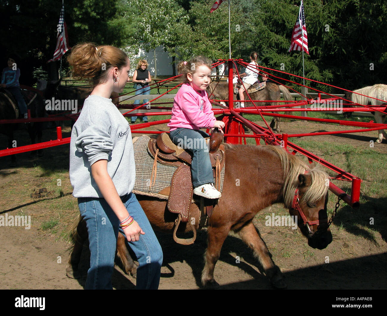 Kids ride ponies horses at a children farm Michigan Stock Photo - Alamy