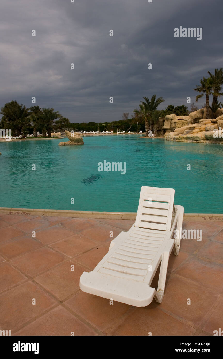 Sunbed by a pool during a tropical storm Stock Photo - Alamy