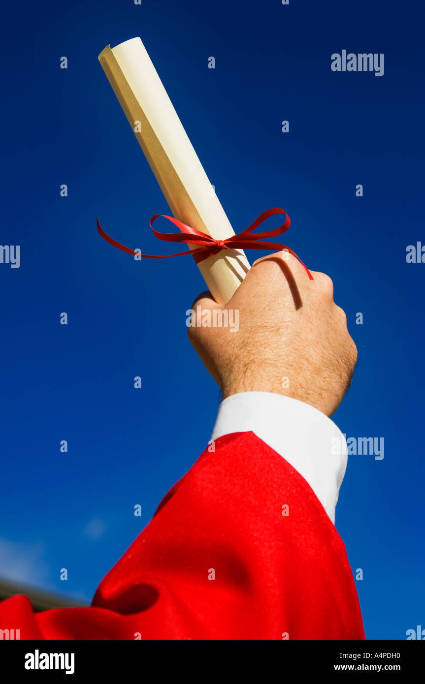 Graduate holding diploma up in the air Stock Photo - Alamy