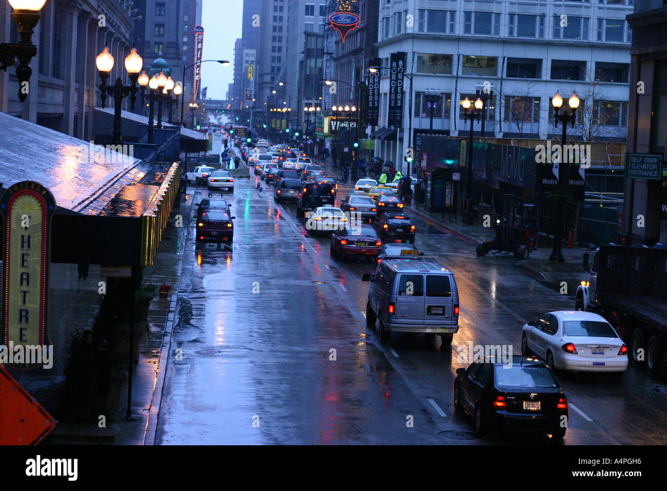 Cars driving through a busy intersection on a rainy and wet night ...
