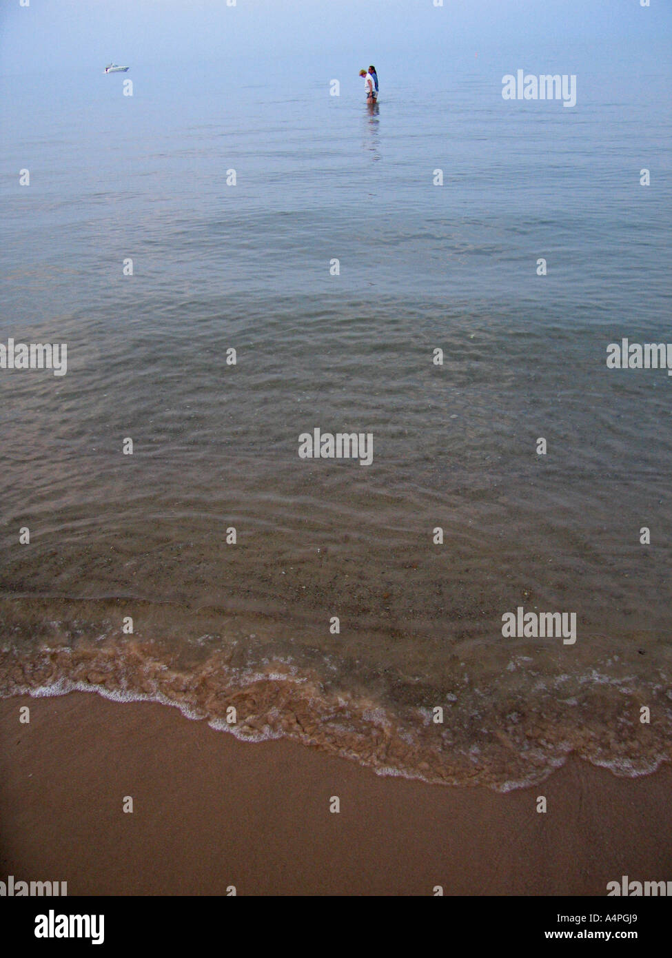 Two people walking in shallow water Stock Photo - Alamy