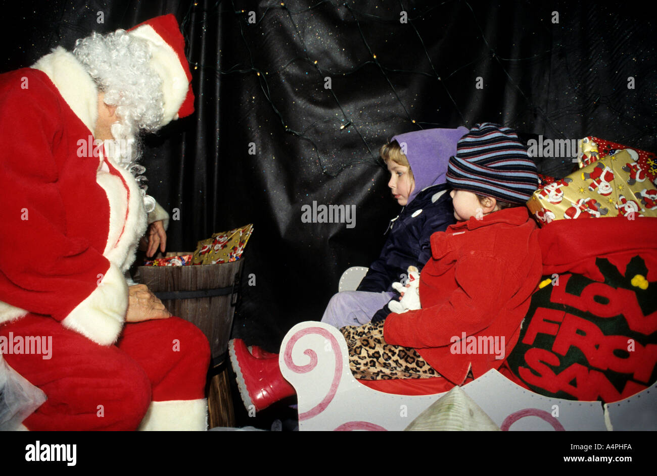 Father Christmas handing out Christmas presents in Santa s grotto Stock ...