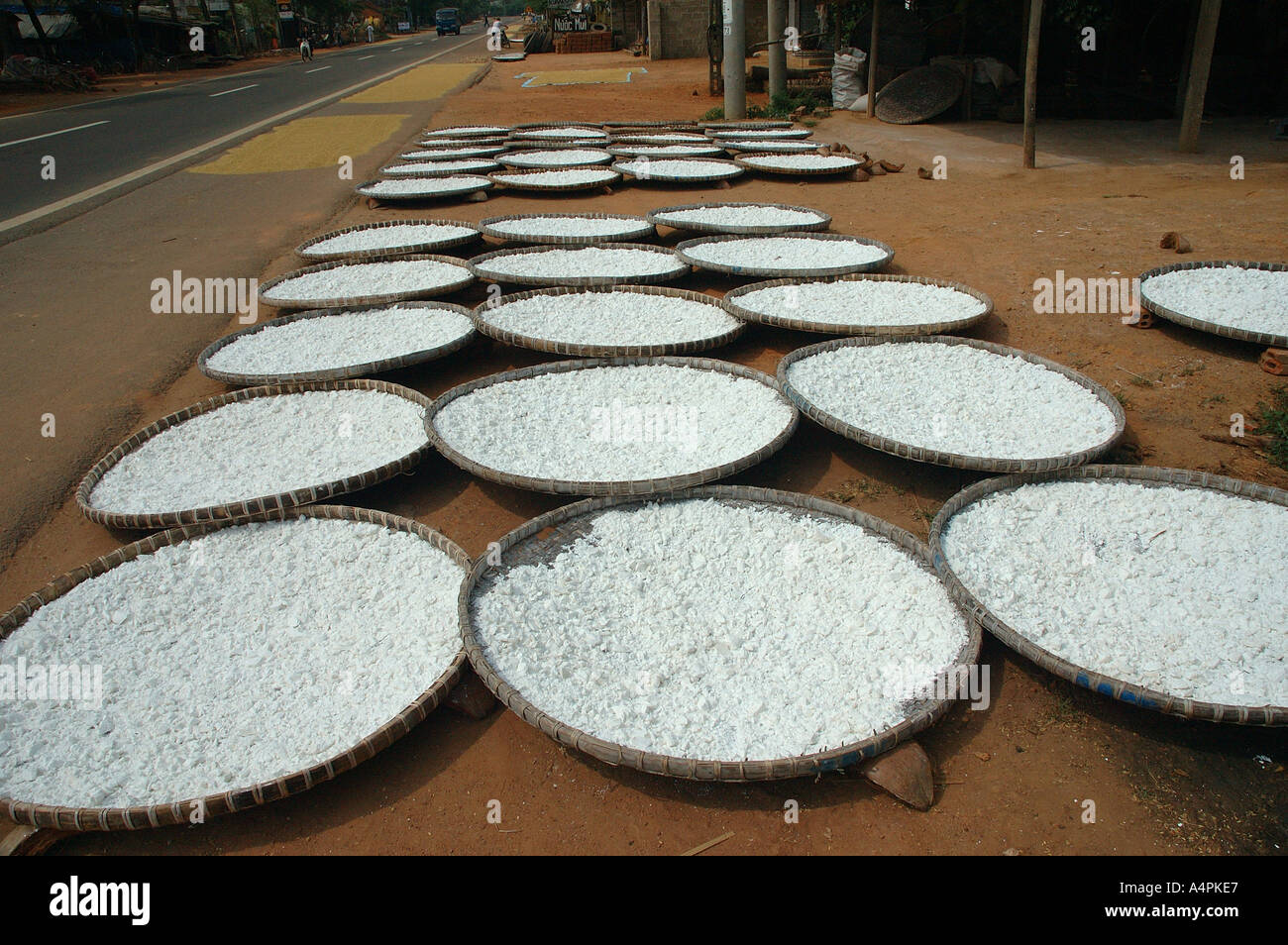 Sliced cassava drying in bamboo trays on the roadside in central ...