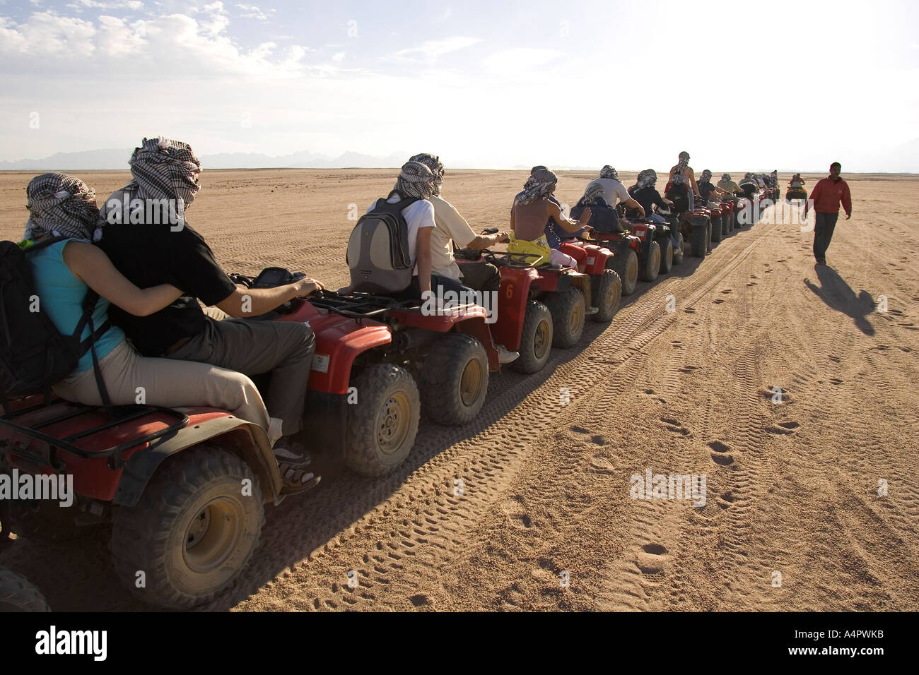 Group of people riding quad bikes in the desert Stock Photo - Alamy