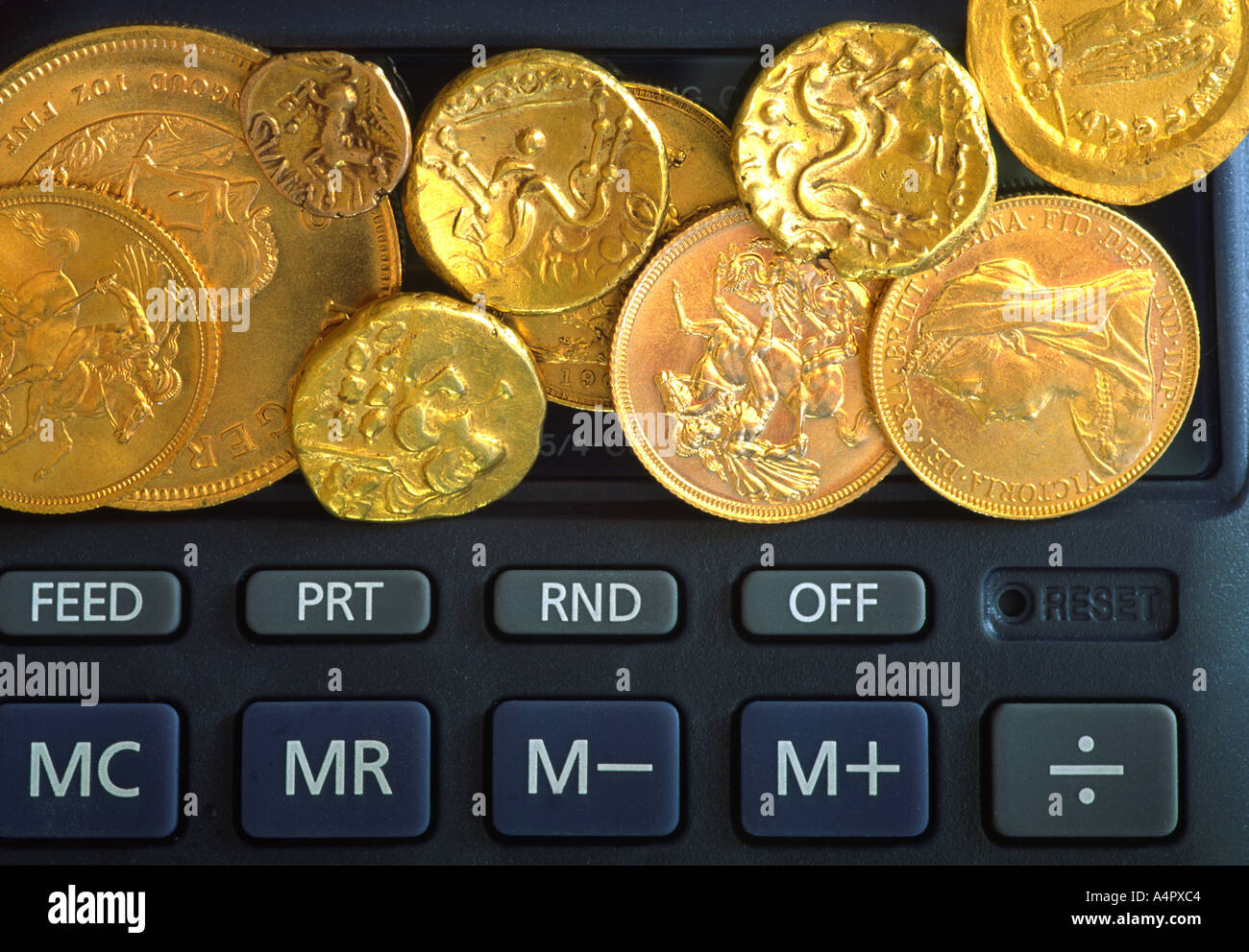 Calculator with gold coins Stock Photo - Alamy