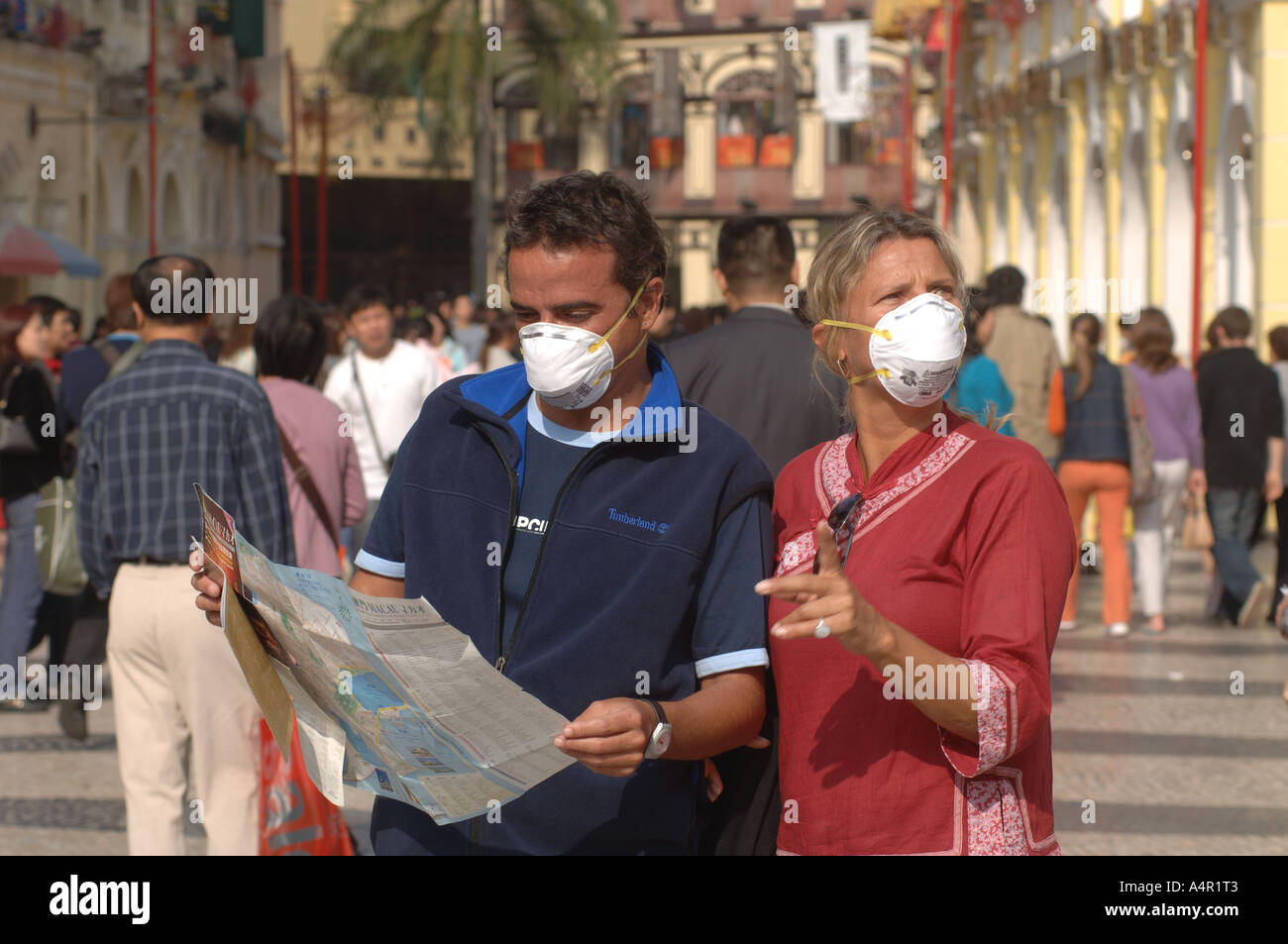 tourist wearing pollution mask in the street, looking to a city map ...