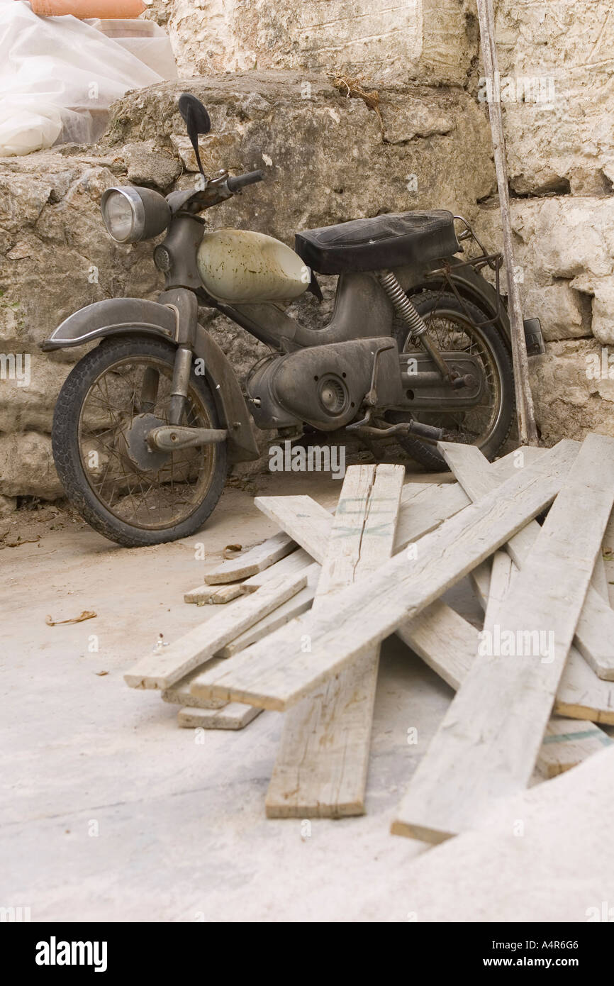Motorcycle leaning against a stone wall Stock Photo - Alamy
