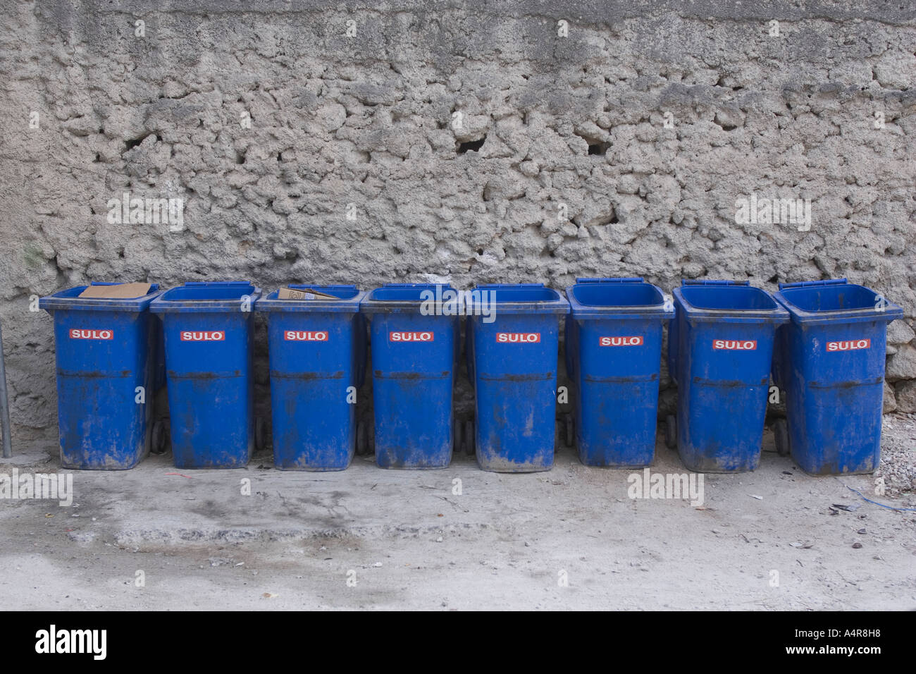 Garbage bins against a wall Stock Photo - Alamy