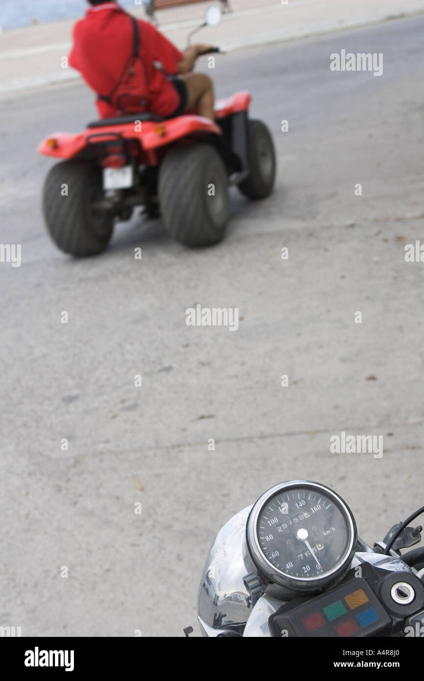 Close up of a speedometer with a person riding a quad bike in the ...