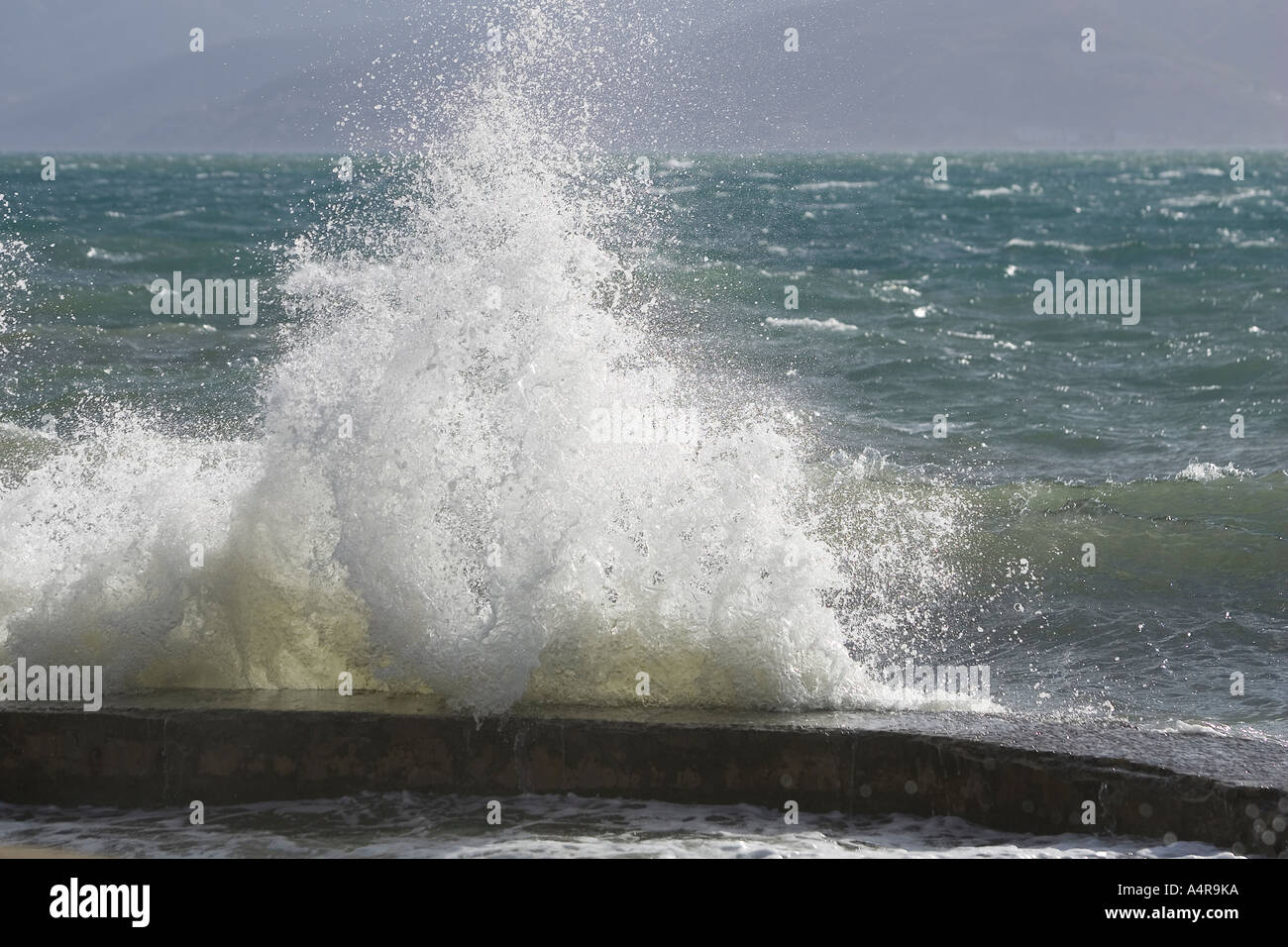 Waves breaking against a concrete barrier Stock Photo - Alamy