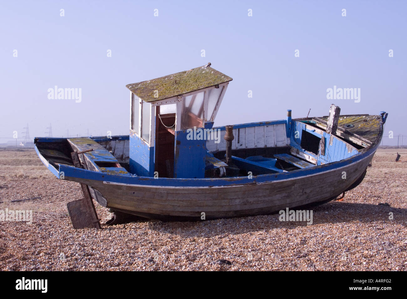 Side view of an abandoned fishing boat left on the shingle beach at ...