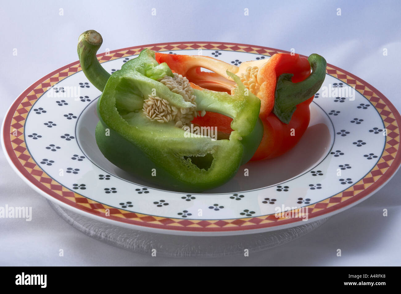 A green and red pepper having been cut open exposing the seed of the ...